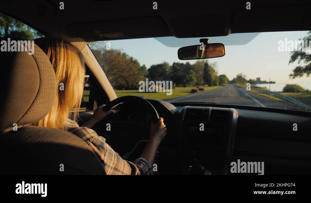 Rear view of Attractive middle-aged woman driving a car in the American ...