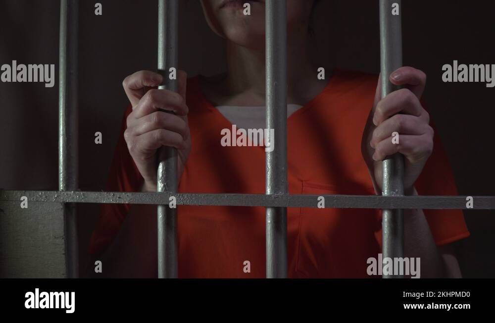 Female Prisoner / Inmate holding bars in a Jail / Prison Cell. Tracking ...