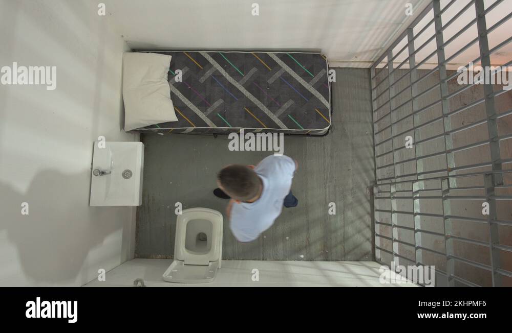 Male Prisoner / Inmate in a Prison Cell. He is pacing the floor ...