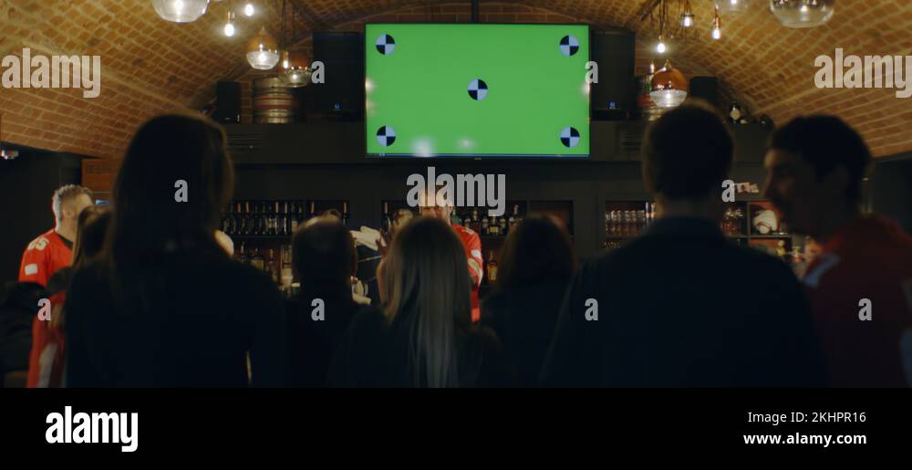 Fans watching a game on TV in a sport pub, green screen chroma key Stock Video Footage - Alamy