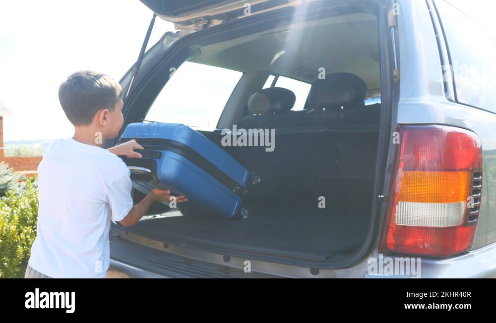 Girl and boy put suitcases into the car boot. Close up. Copy space. 4K ...