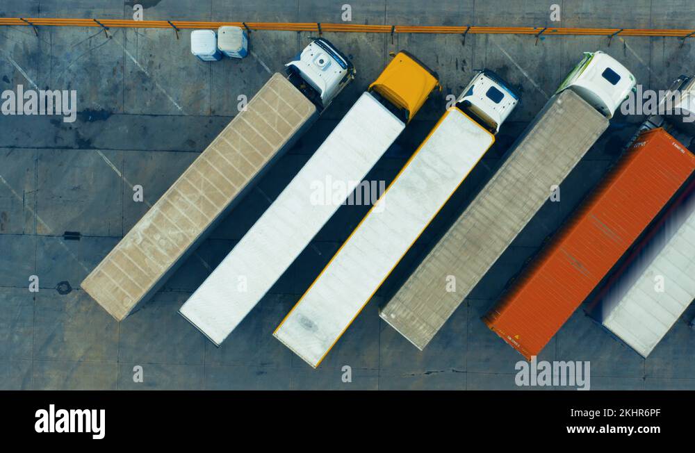 Aerial top down view of the semi trucks with cargo trailers standing ...