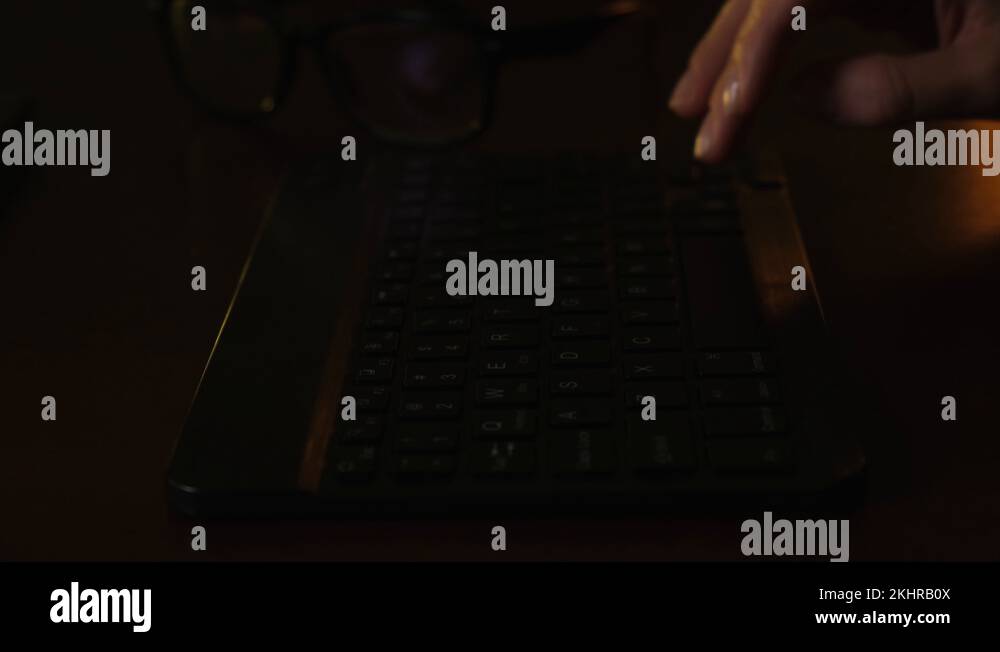Girl works computer in office behind LED keyboard. Businesswoman ...