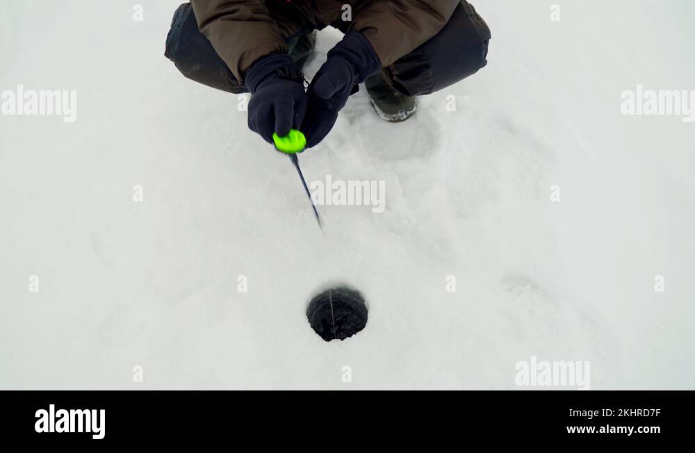 Fisherman ice fishing on the river. A man on winter fishing. View from ...
