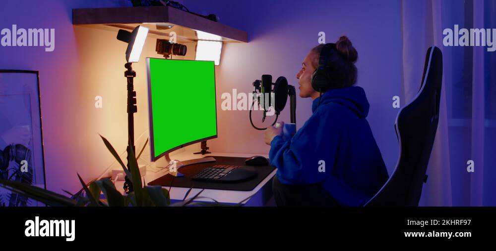 Caucasian teen girl recording a podcast or doing live stream from home ...