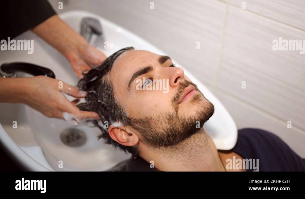 Woman applying shampoo massaging hair customer Man wash hair in beauty ...