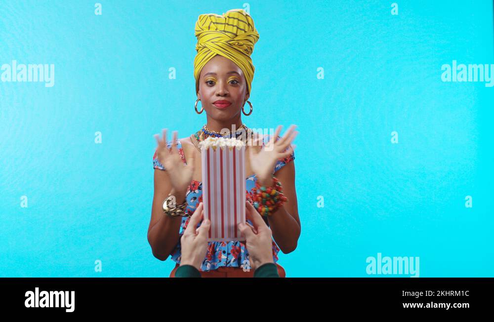 African young happy girl gets a bucket of fresh popcorn eating fast ...