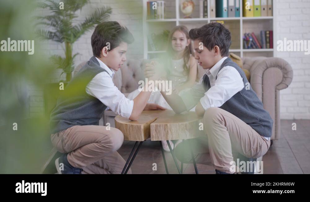 Two identical twin brothers competing in armwrestling and talking as ...