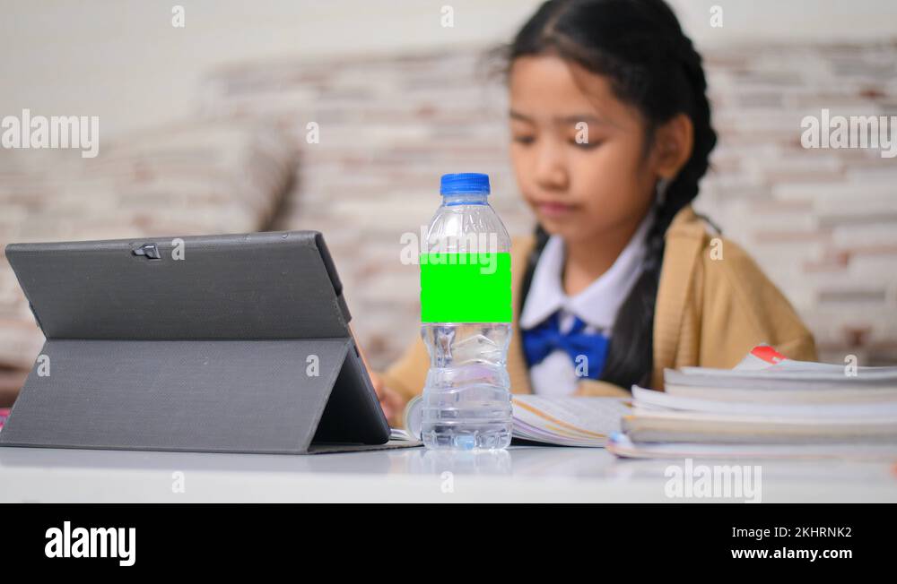 Asian little girl doing homework with bottle and green screen Stock ...