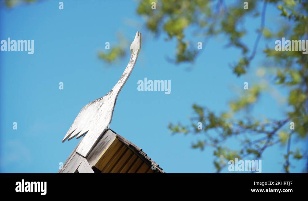 A wooden ascending white bird on the top of roof ridge in Udege village ...