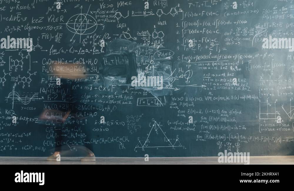 Zoom-in time lapse of intelligent female teacher writing formlas on ...