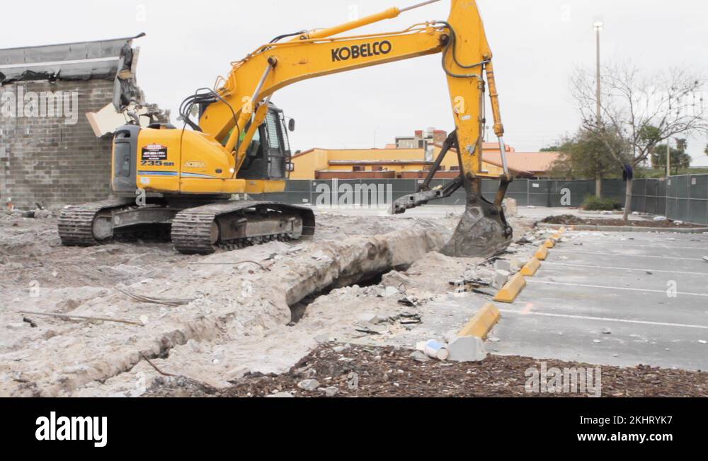 Heavy construction equipment almost tips and falls over trying to grab ...