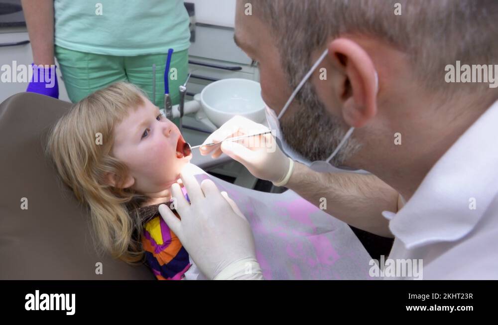 Dentist conducts a routine examination of the child's oral cavity Stock ...