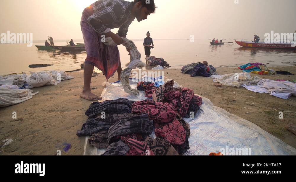 people washing clothes in polluted Ganges river and drying in Varanasi ...