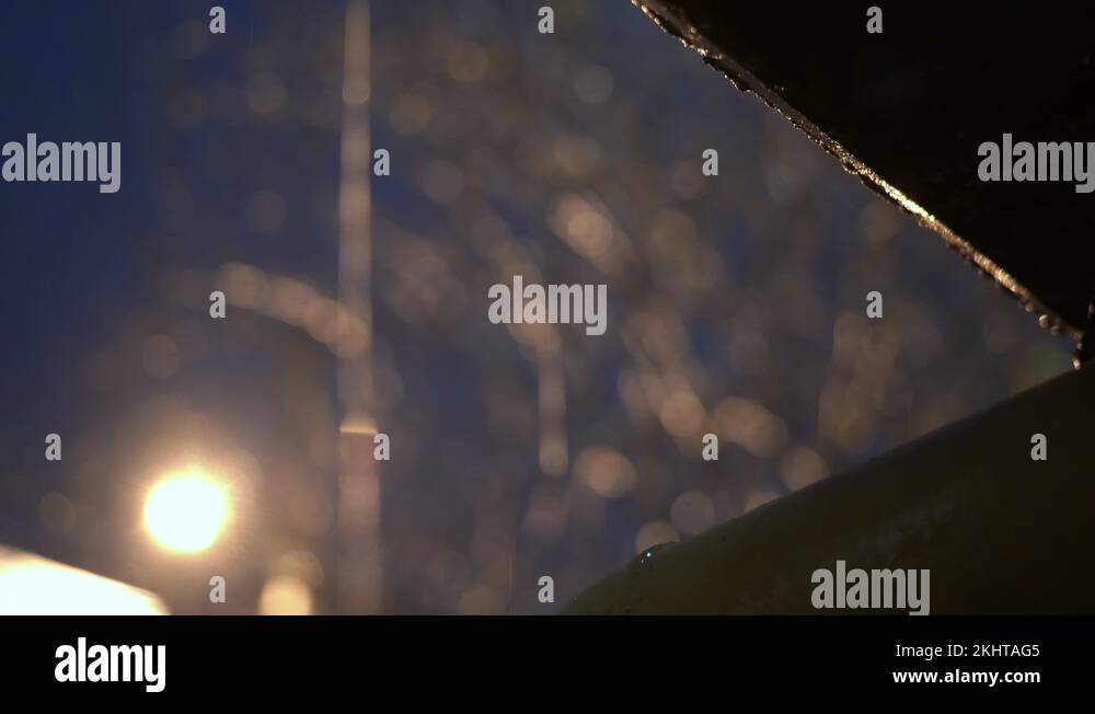 Rainy night city street, dark gateway, rain drops dripping, lit by ...