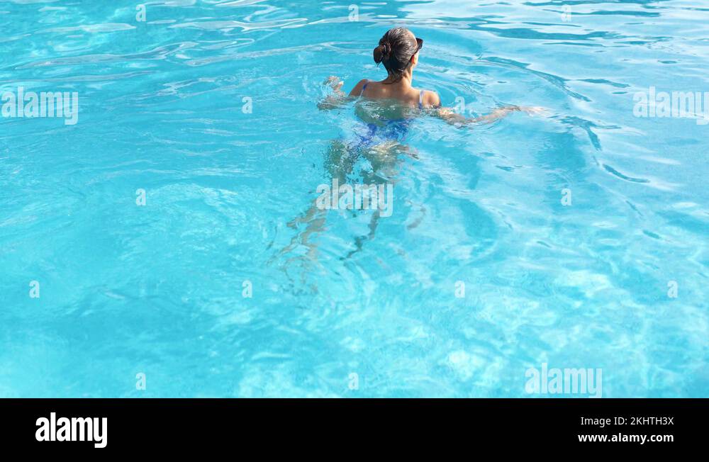 beautiful woman swiming on back in swimming pool At Luxury hotel spa ...