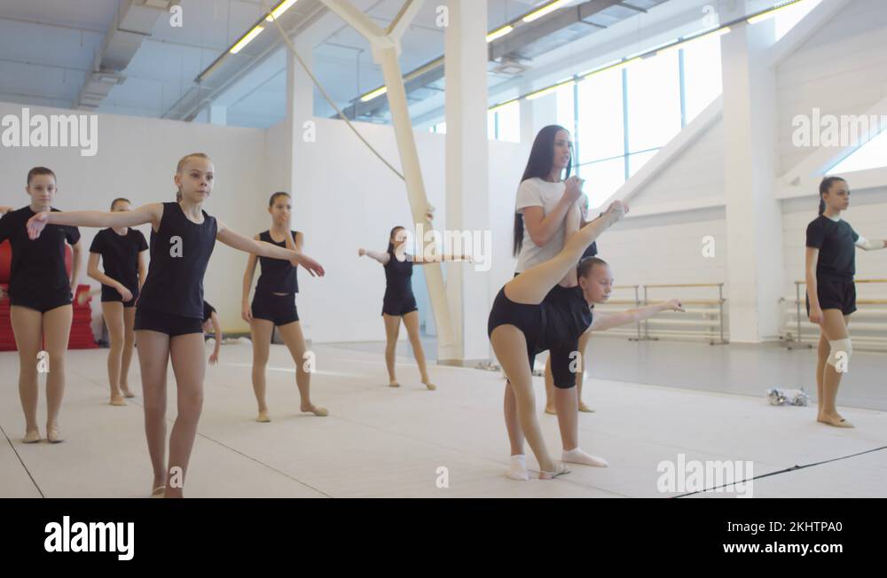 Female Cheerleading Coach Helping Girl Stretch Stock Video Footage - Alamy