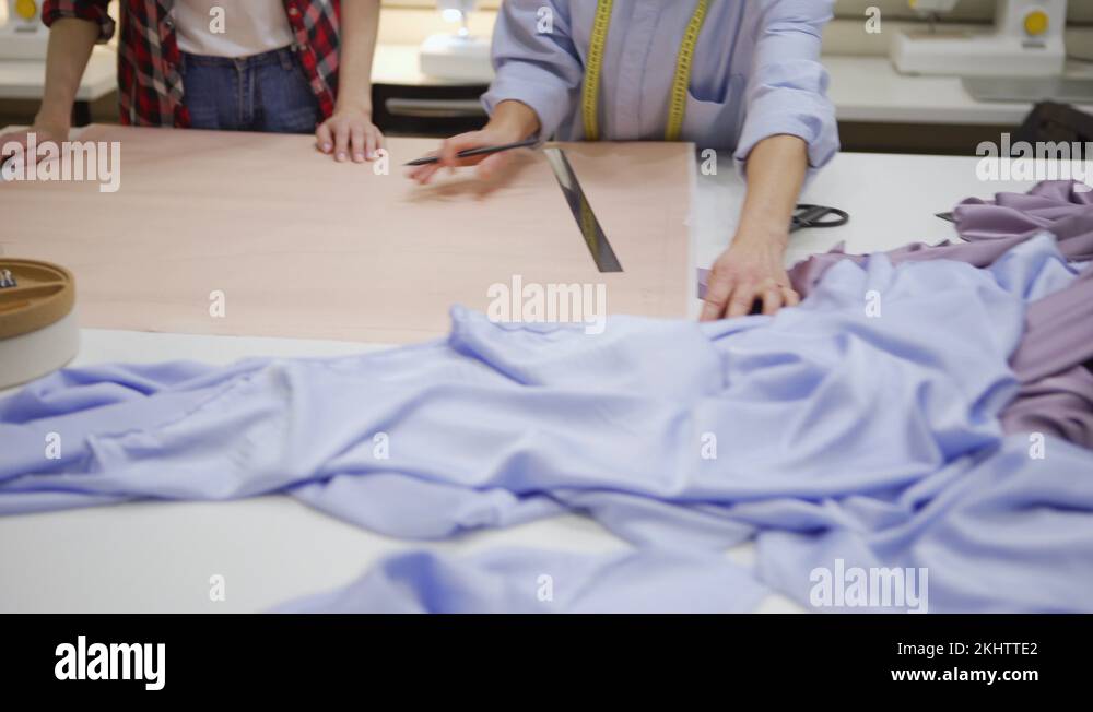 Tailor explaining student how to draw sewing pattern in studio Stock ...