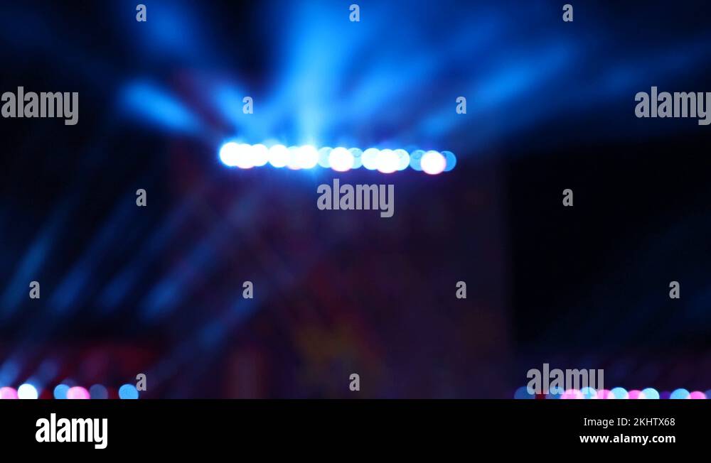 Spot lights on top of building, blue neon flares on dark night with ...