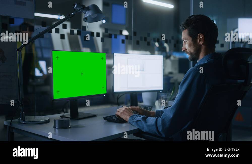 Engineer Works on a Computer, Two Monitor Screens Show Chroma Key ...