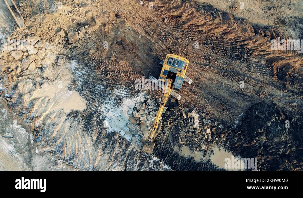 Top view of a borrow pit with an excavator digging ground. Heavy ...