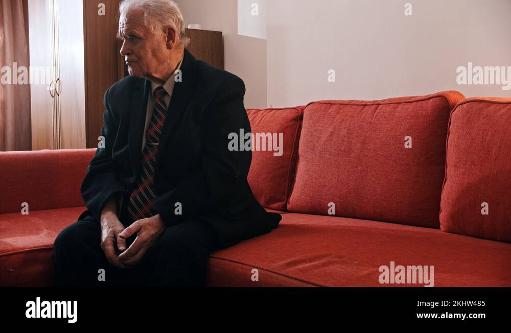 Elderly grandfather - sad old grandfather is sitting on a sofa Stock ...