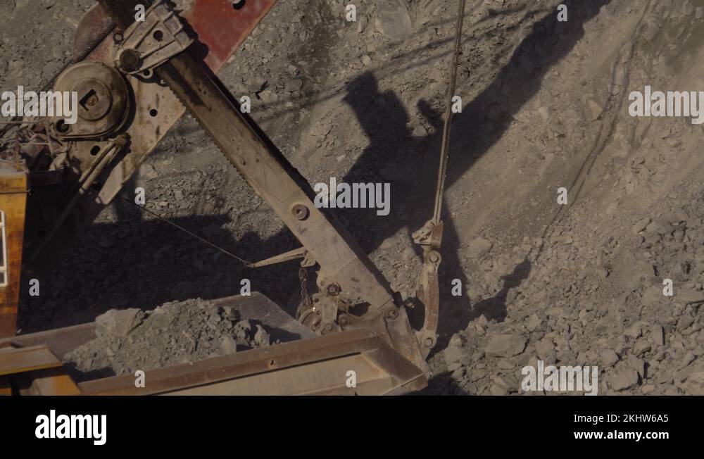 A huge mining excavator pours soil into the body of a large multi-ton ...