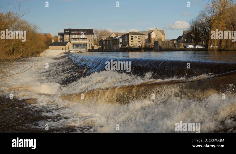 Slow Motion of a flooded UK river creating a heavy waterfall downstream ...