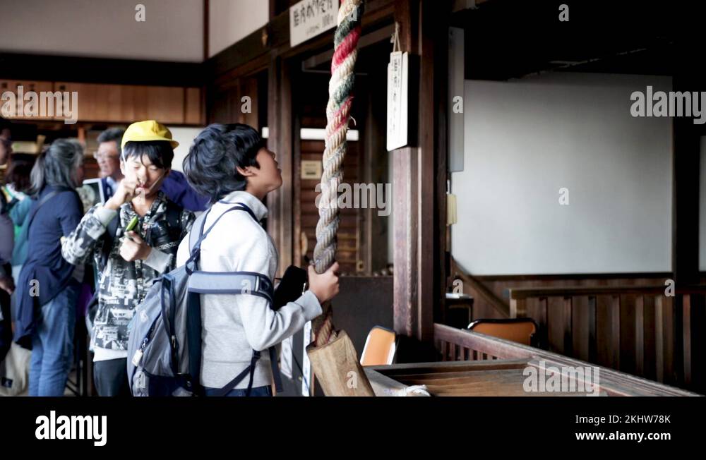 Japanese kid ringing the bell at the temple and praying - Kyoto Stock ...