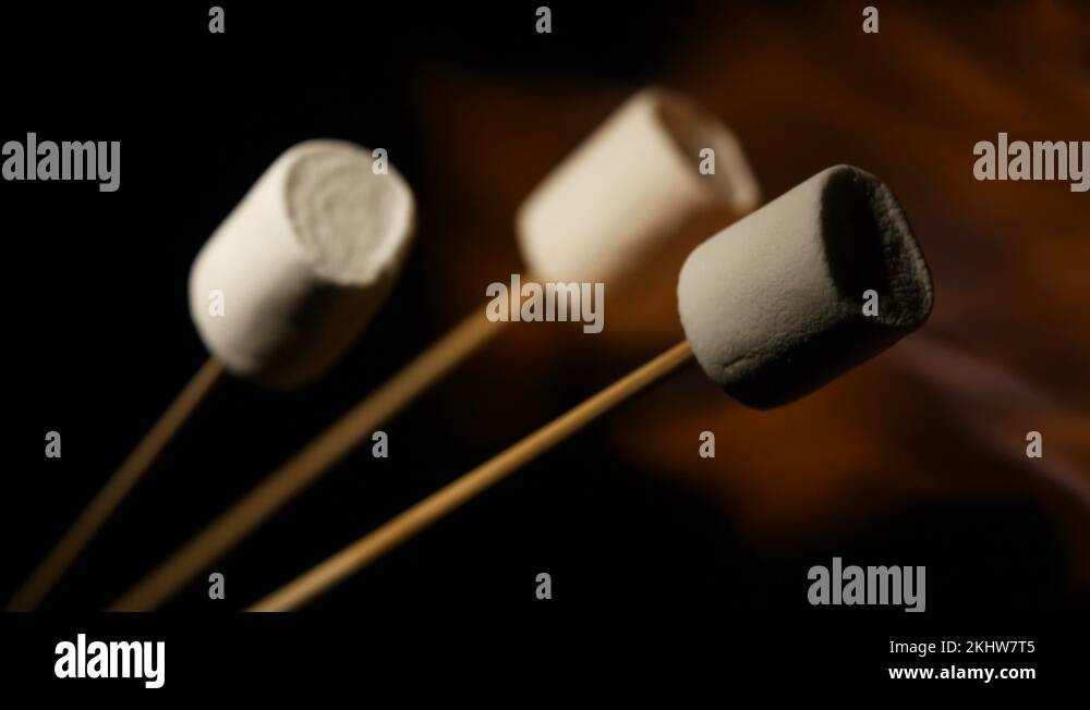 Fire roast marshmallows. Marshmallow on fire flames on black background ...