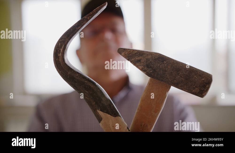 Man holding hummer and crowbar in front of his face. Close up shot ...