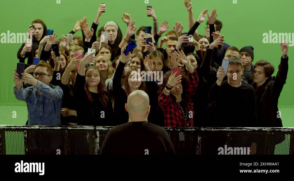 GREEN SCREEN Front view huge crowd dancing and cheering behind control ...