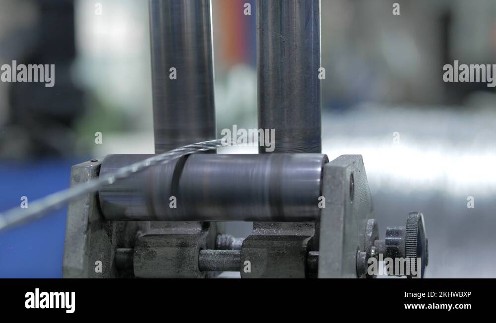 Production line of the cable. Close-up of a steel cable moving along a ...