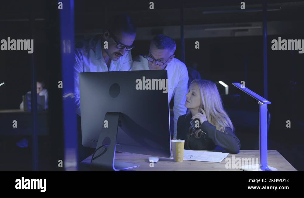 Diverse business people working in dark office using computers Stock ...