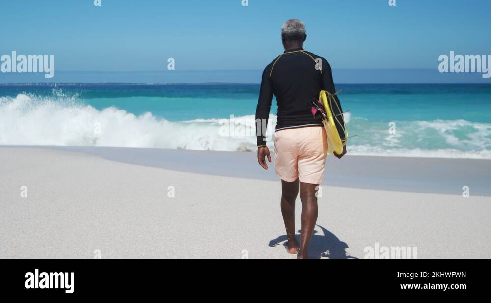 Rear view old man walking with surfboard at the beach Stock Video ...