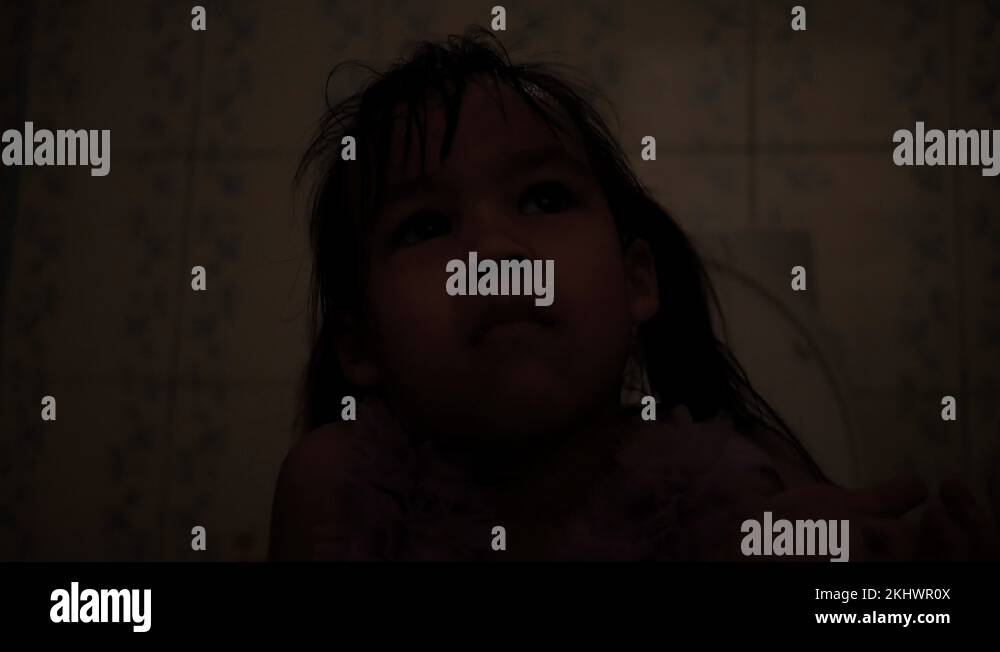 Little girl feel scared while sit on toilet bowl with flickering light ...