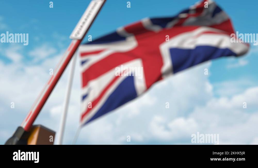 Barrier gate with QUARANTINE sign being closed with flag of the UK as a ...