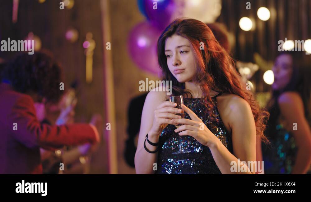 Sad and pretty lady at party feeling alone in front of the camera ...