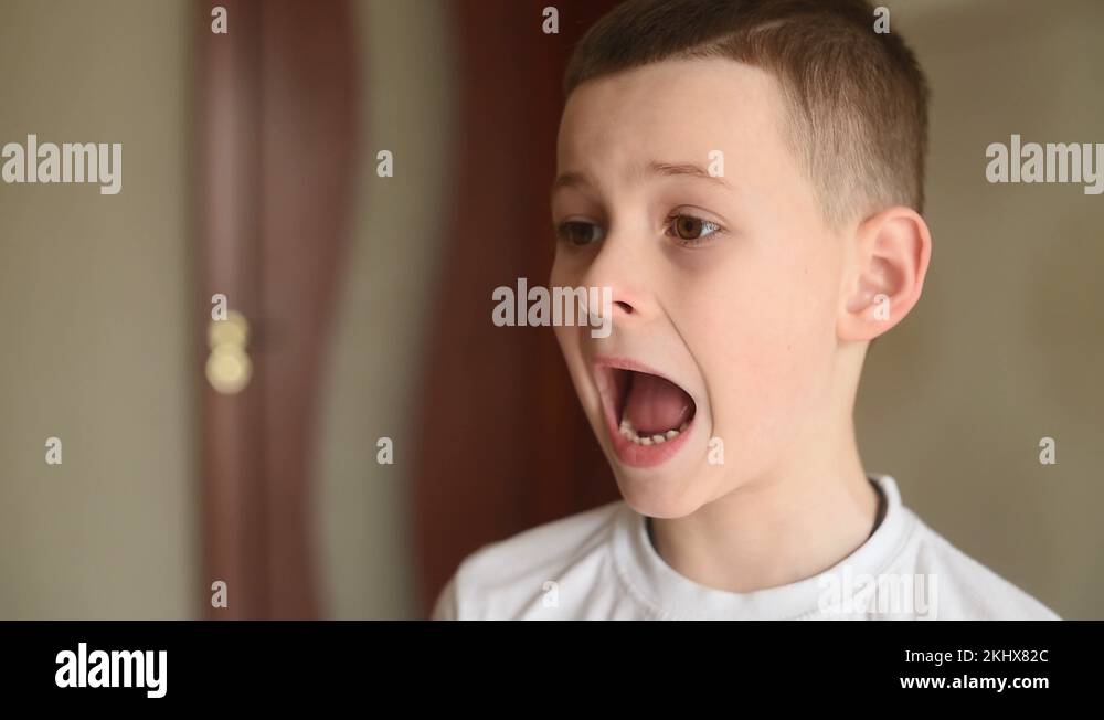 mother loosens and tries to pull out a baby tooth to a small child boy ...