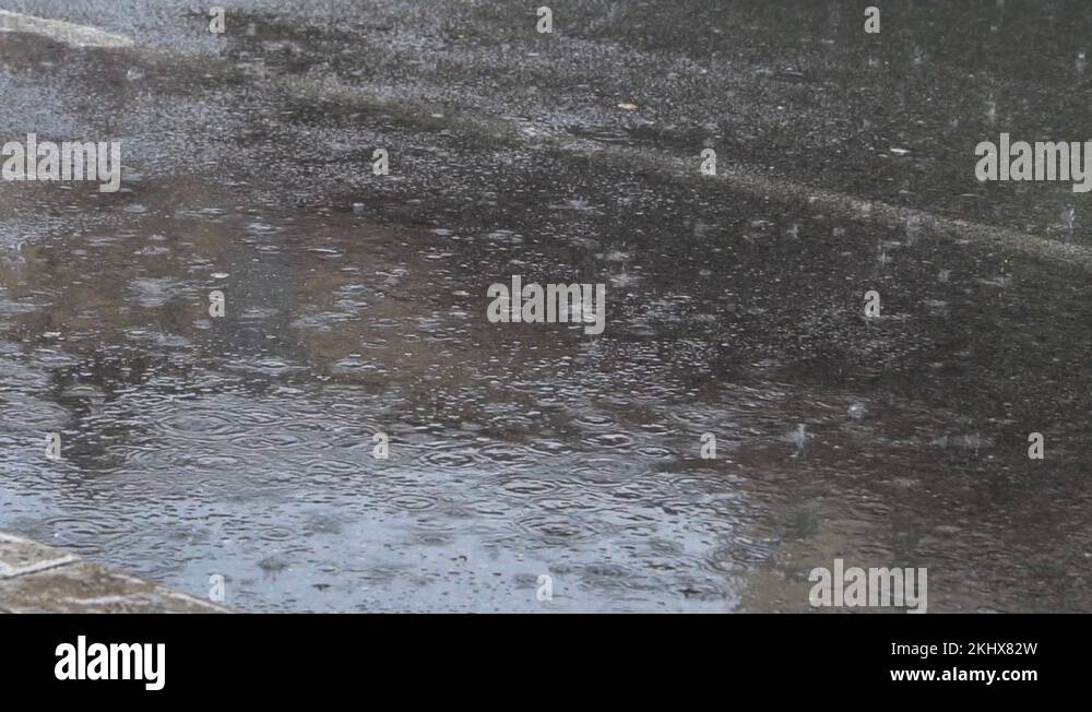 Autumn rain water drops falling into big puddle on asphalt, flooding ...