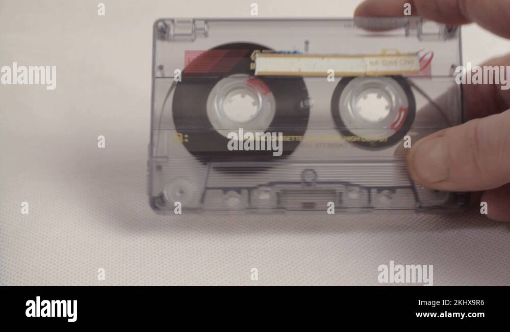 Hand holding retro cassette tapes into radio cassette player close up ...