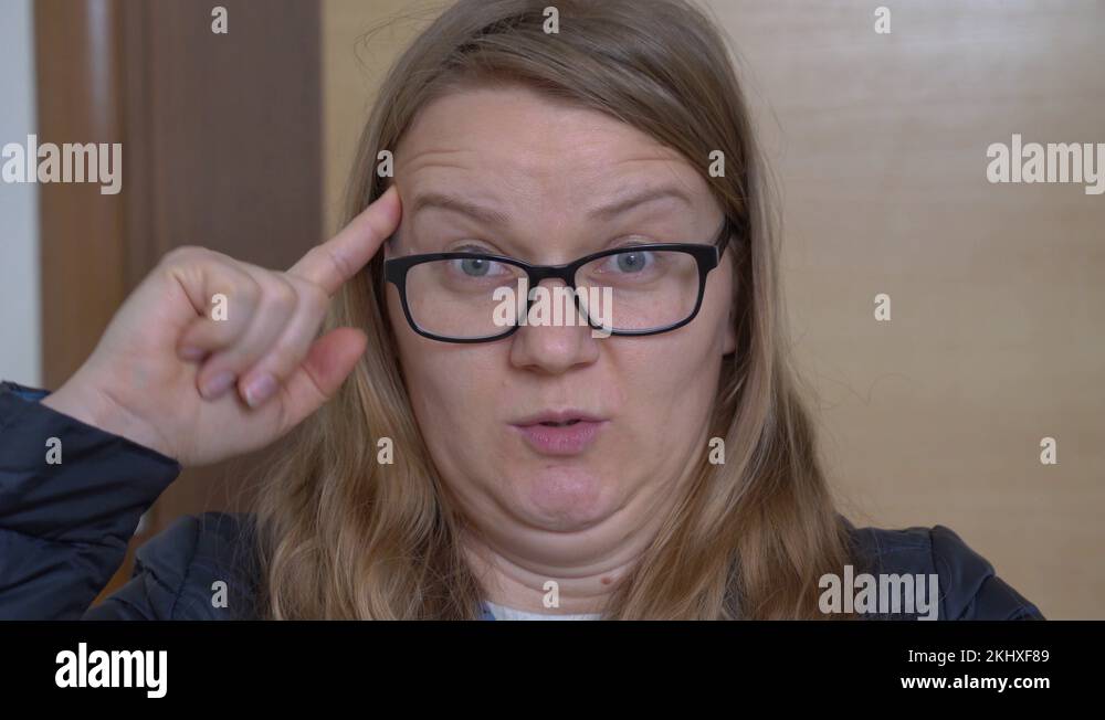 female in glasses makes circular motion with her index finger near her ...