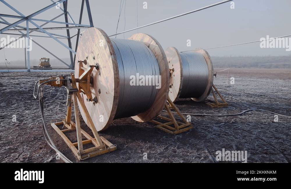 large bobbin with high-voltage wire near transmission towers Stock ...