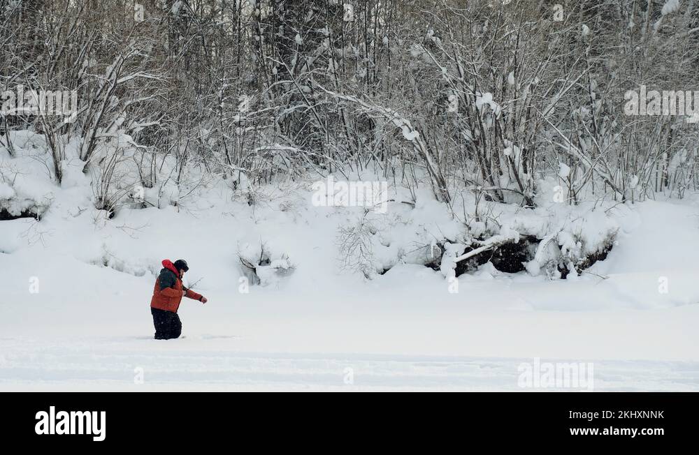 Ice fishing. Fisherman fishing on frozen river. Man catching fish in ...