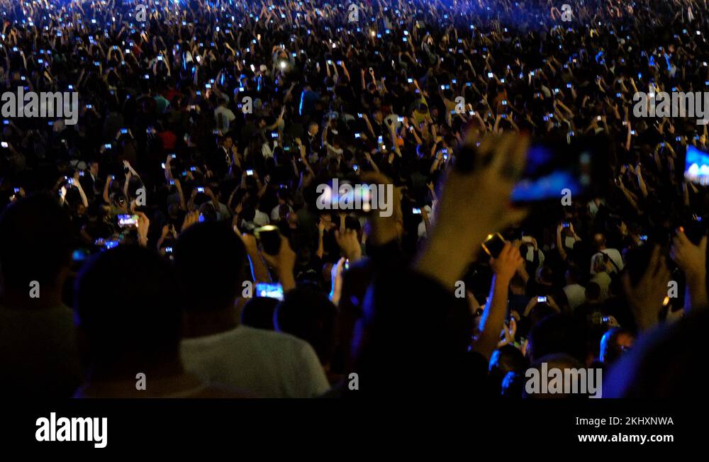 Crowd of people standing in fan zone during rock or pop music concert ...