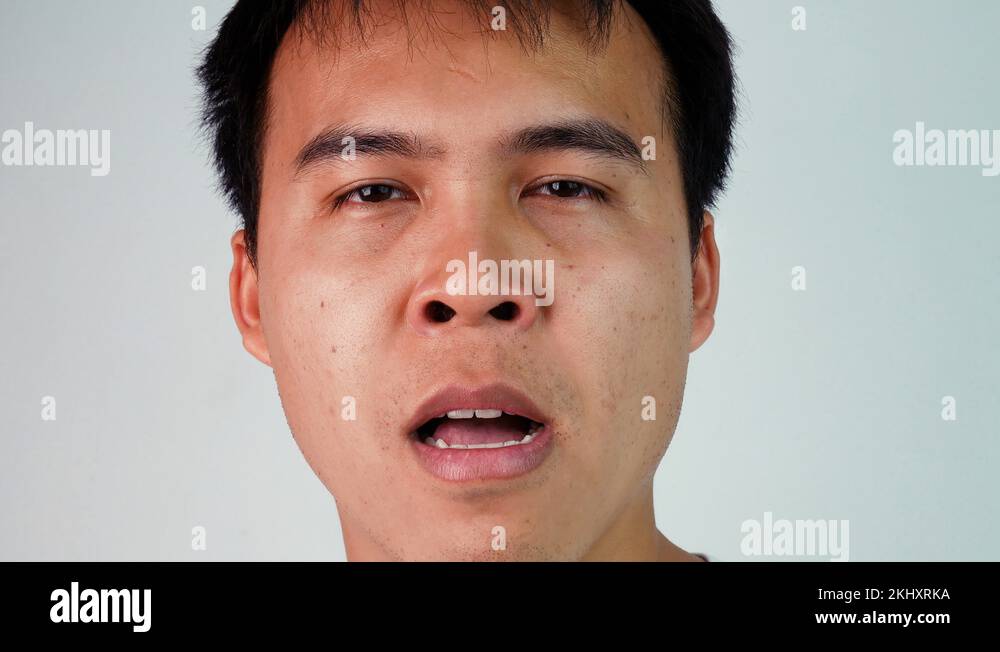 portrait of tired Asian man expressing drowsy and yawn over grey ...