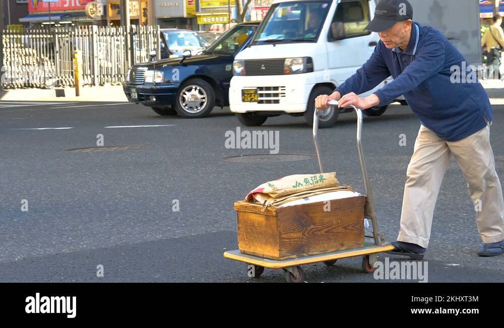 The old man pushing the cart on the side of the road in Osaka Japan ...