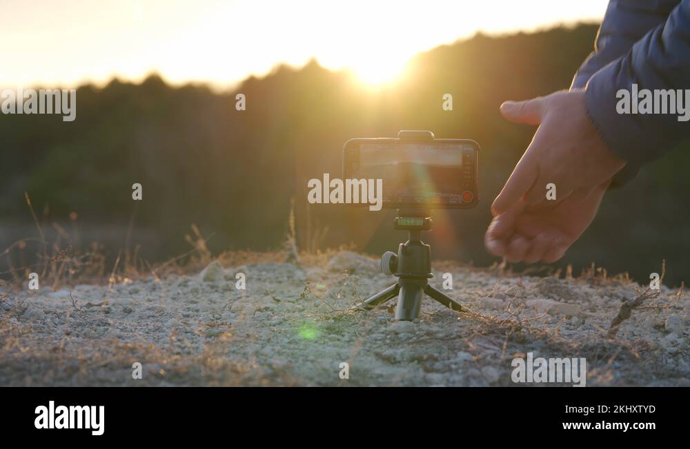 Taking travel landscape video with mobile phone camera during sun ...
