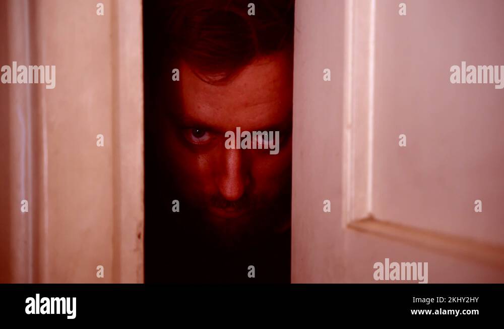 Horror crazy killer waiting for victim in darkness behind the doors ...