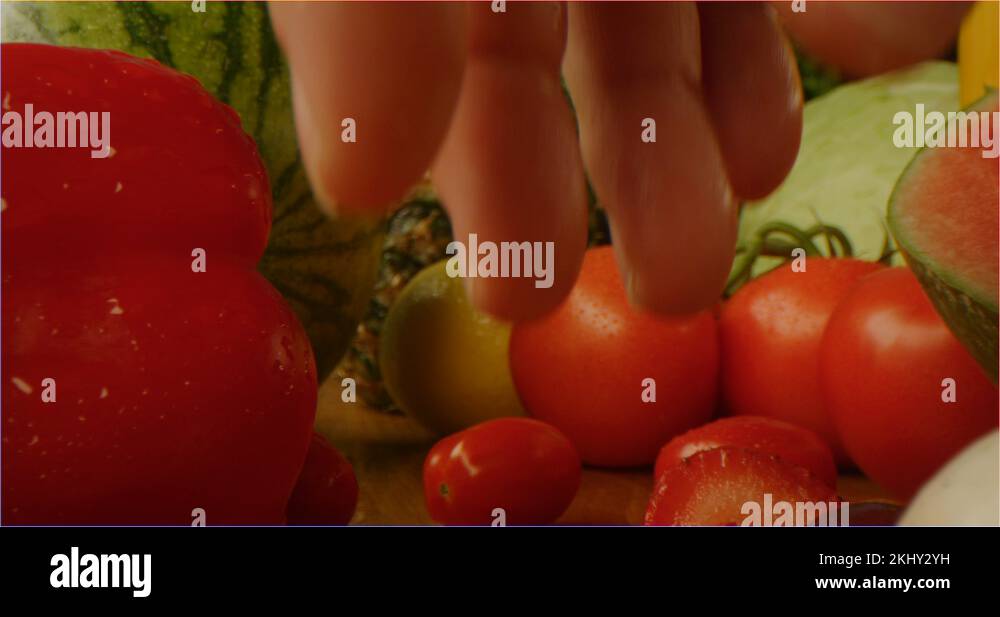 Pushing through composition of fruits and vegetables, sliding over ...